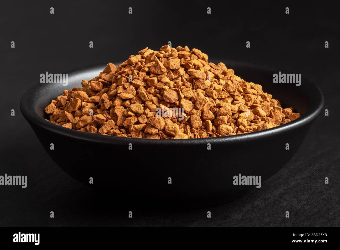 Dry instant coffee in a black ceramic dish isolated on black Stock ...