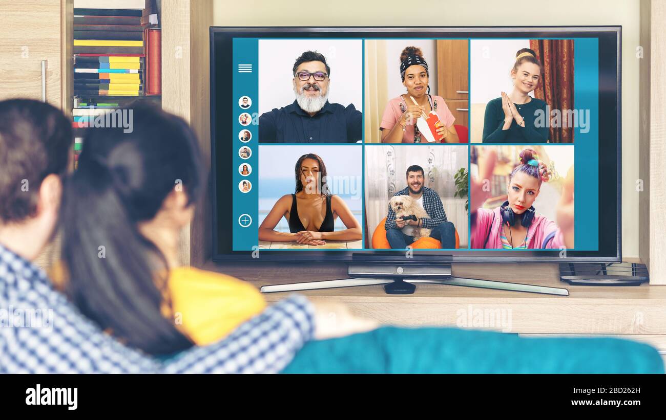 Millennial couple having fun on video call from home with multiracial ...