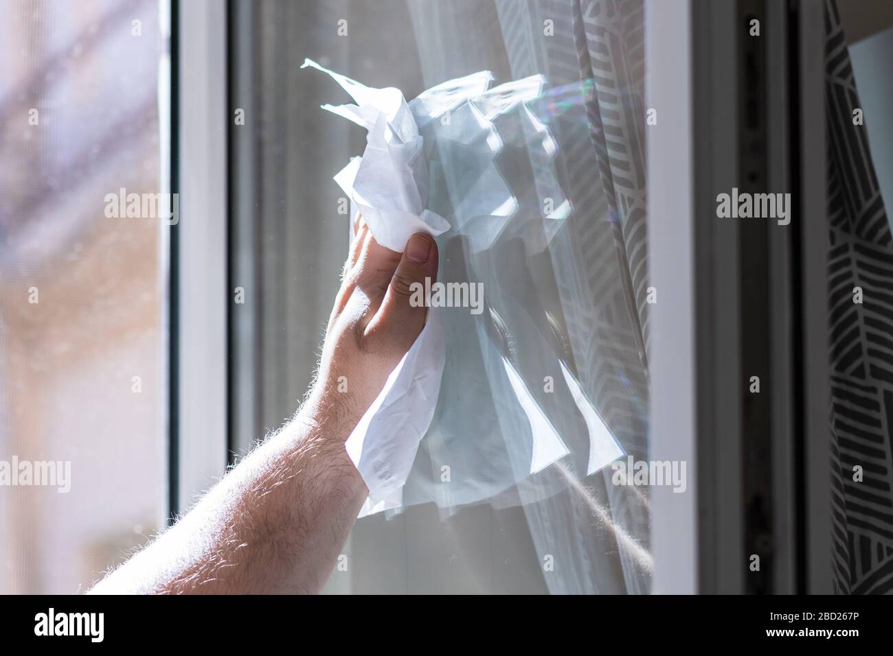 Man wiping window using paper towels, cleaning services concept ...