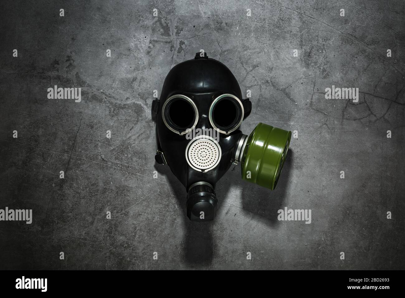Gas mask on a black stone background with a green filter cartridge ...