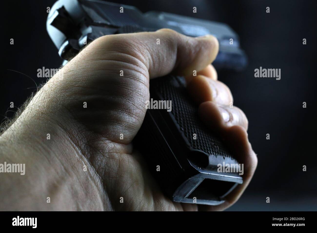 Hand holding a pistol Stock Photo - Alamy