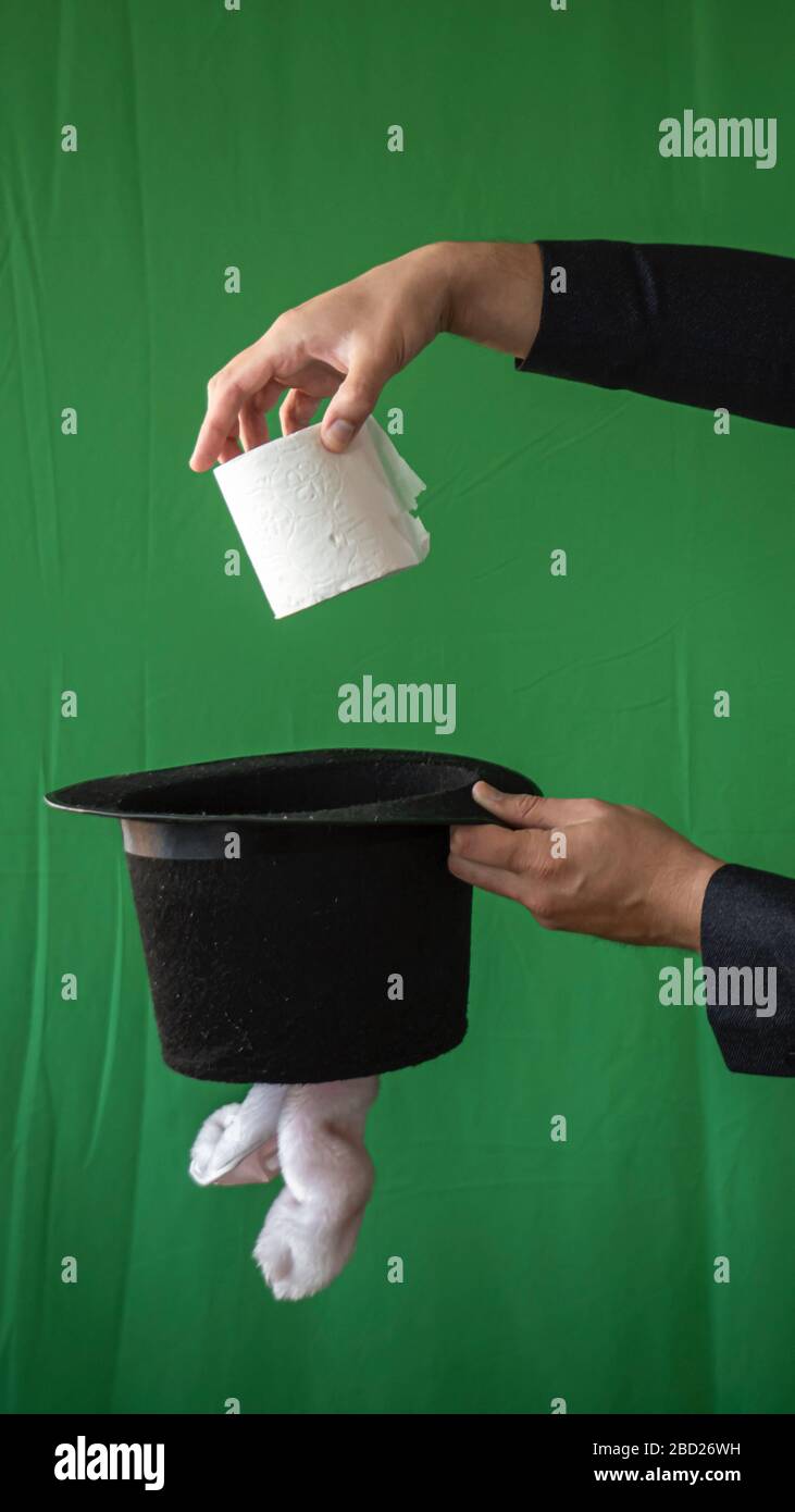Man is taking a toilet paper from a hat like a wizard. Concept photo of ...