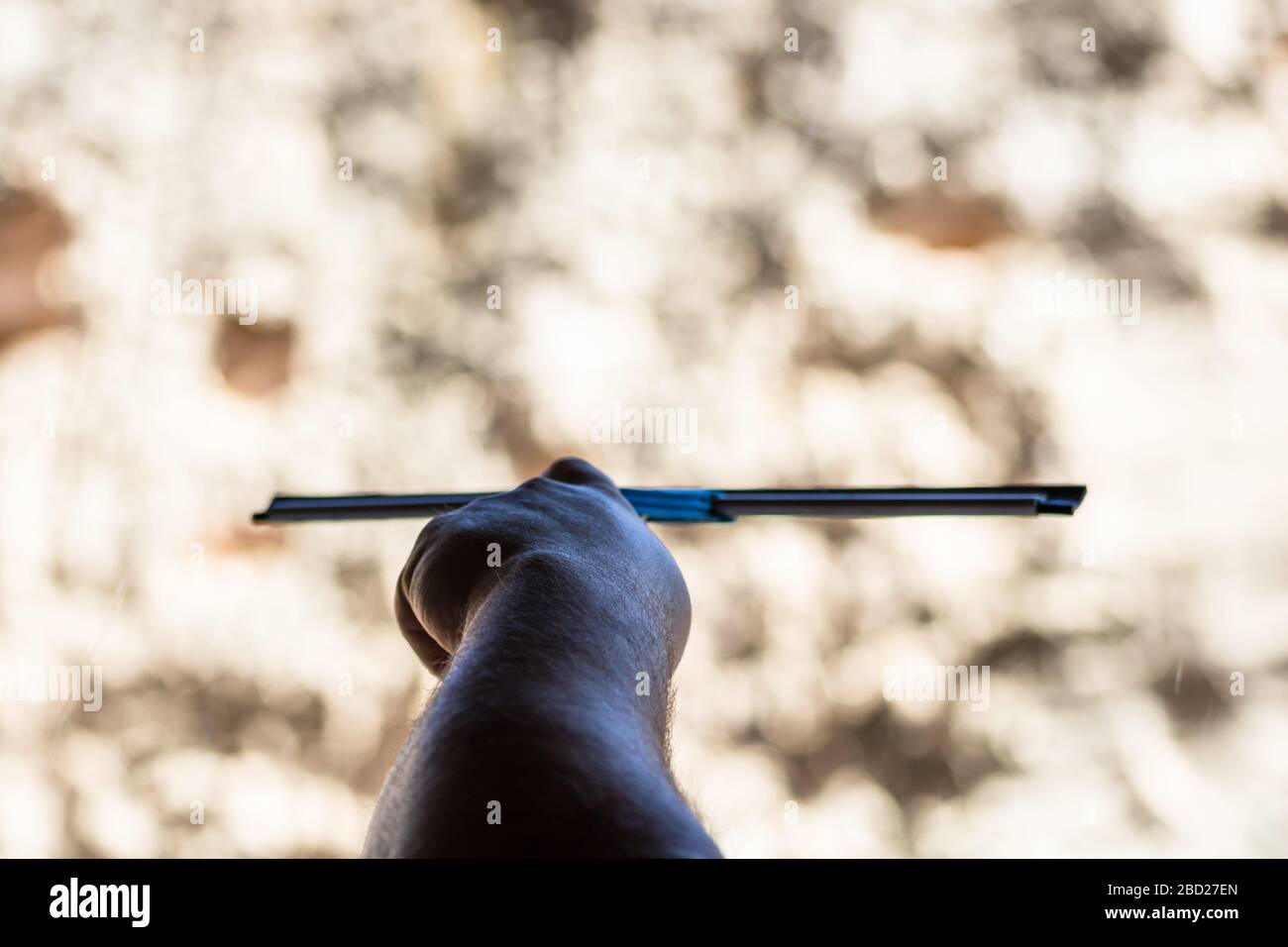 Man cleaning window using window cleaning squeegee and cleaning sprayer ...