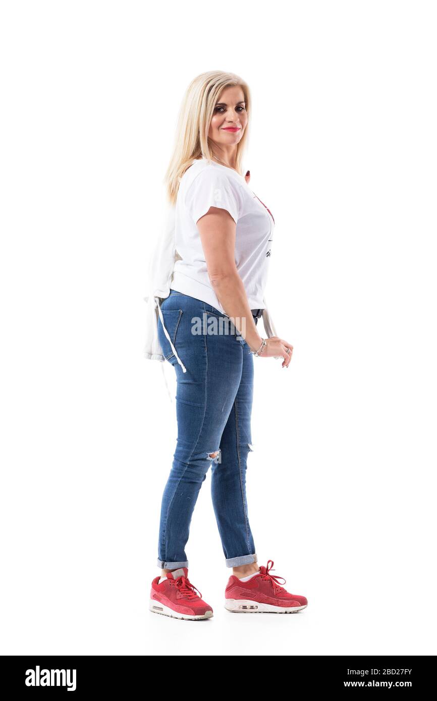 Comfortable candid mid age woman walking and carrying shirt over ...