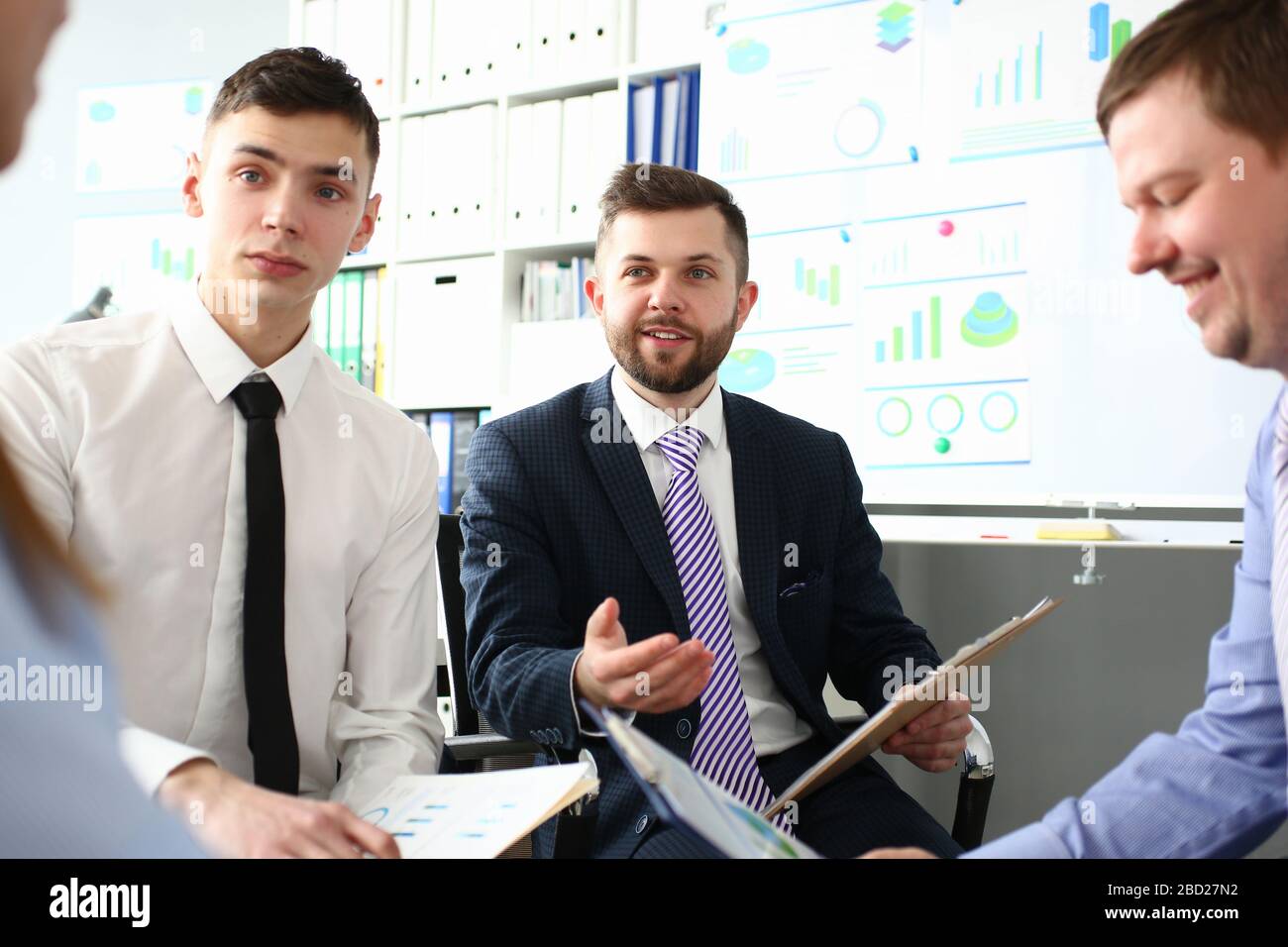 Bunch of businessmen sitting in office solving current problems Stock ...