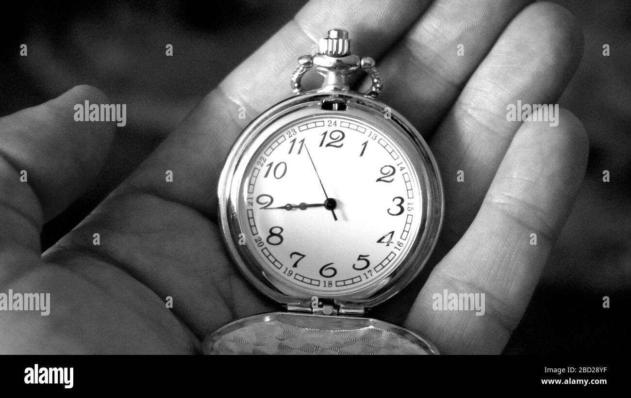 Old antique pocket watch showing time being held in hand. Close up shot ...