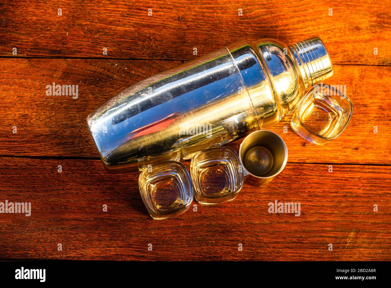 Cocktail shaker accessories and shots glasses on a wooden board. Bar ...