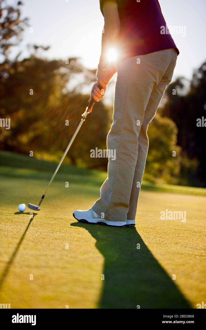 Mid adult woman positioning her golf club to hit the ball Stock Photo ...