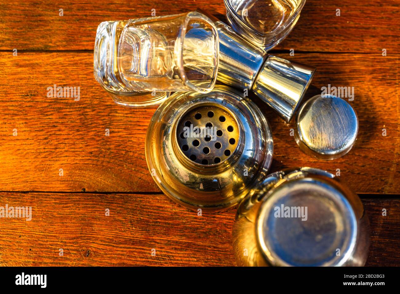 Cocktail shaker accessories and shots glasses on a wooden board. Bar ...