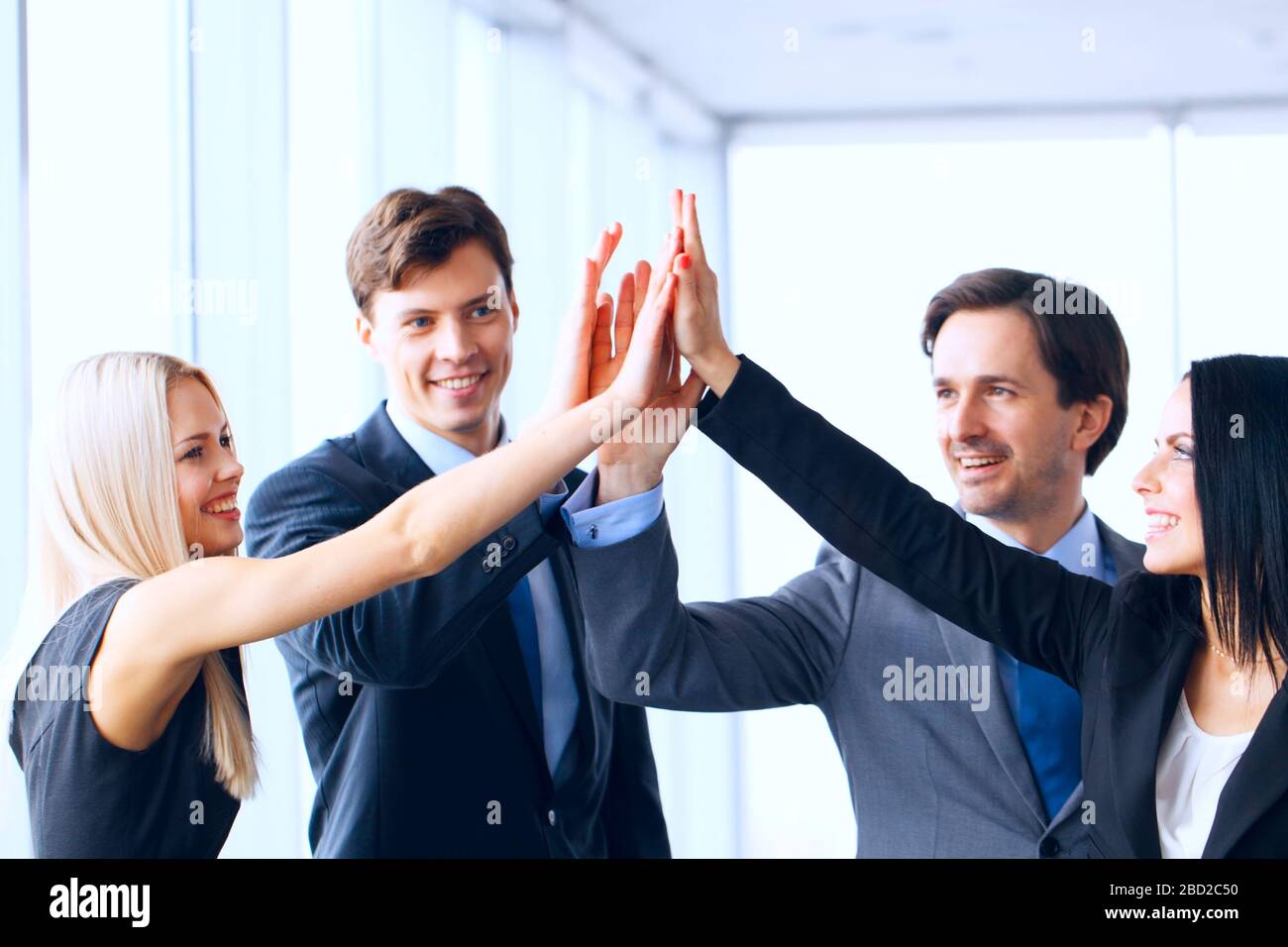 Successful business people celebrating giving high five Stock Photo - Alamy