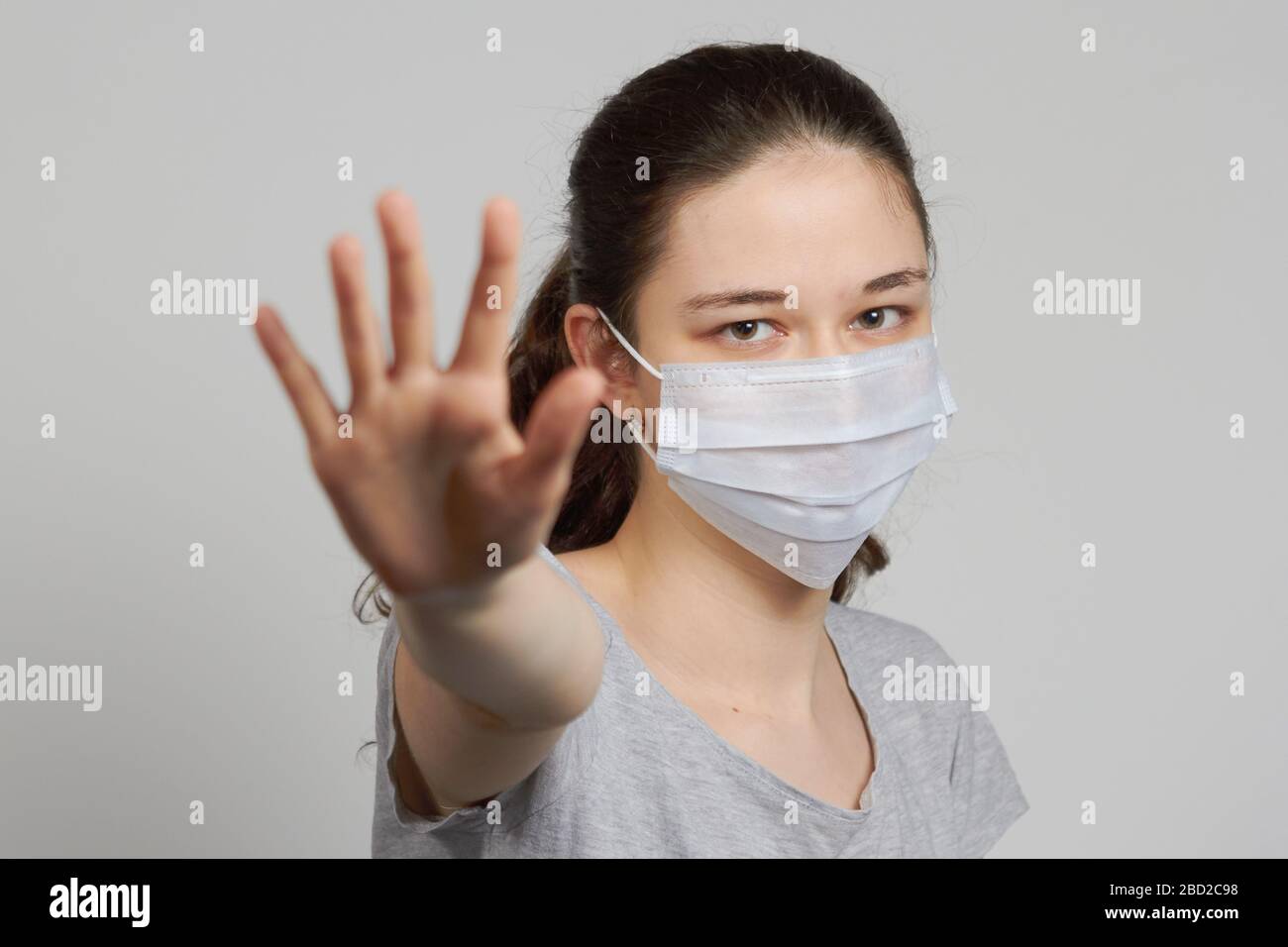 a girl in a mask shows a stop gesture fearing for the health of people ...