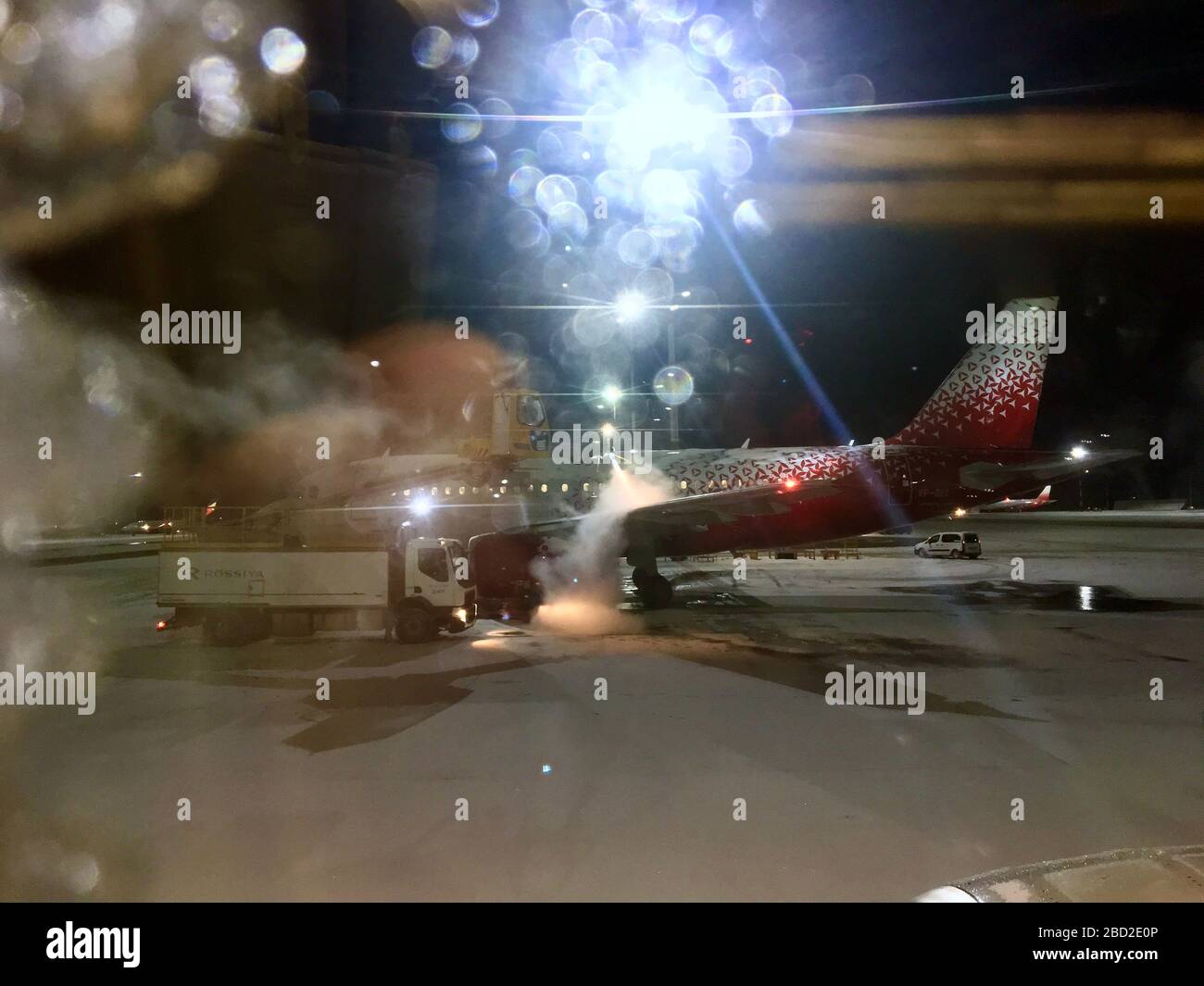 Plane and special equipment on the runway in the dark from lanterns ...