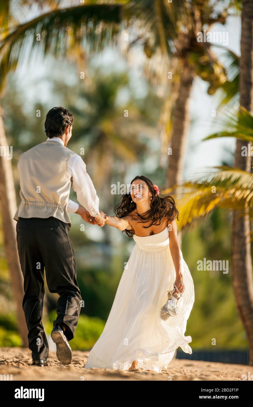 Radiant bride grinning at her new husband as they have fun together on ...