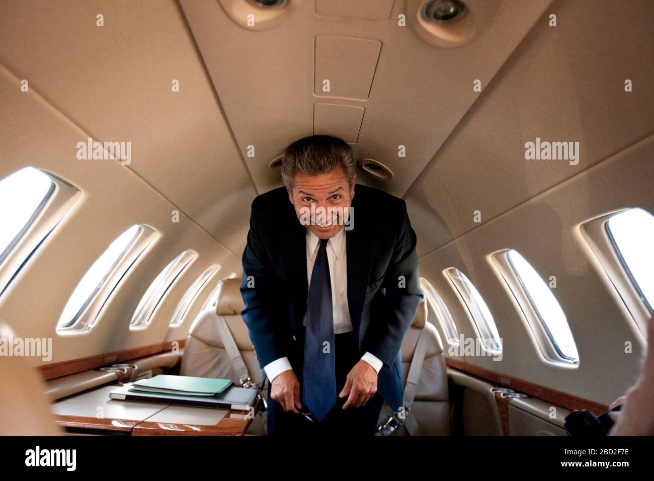 Businessman standing in a private jet and smiling Stock Photo - Alamy
