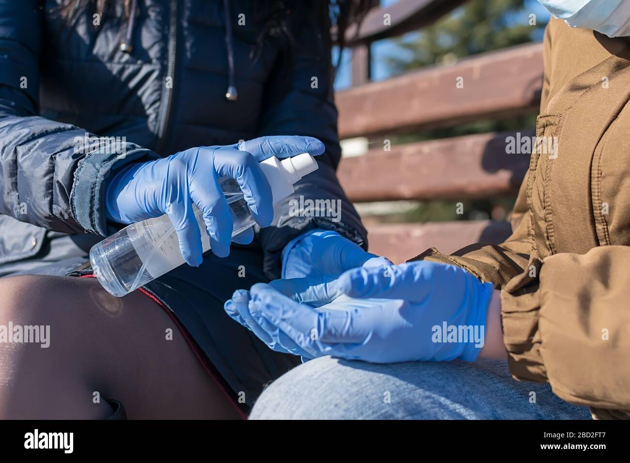 a mother with a child sprays her hands with an anti bacterial anti ...