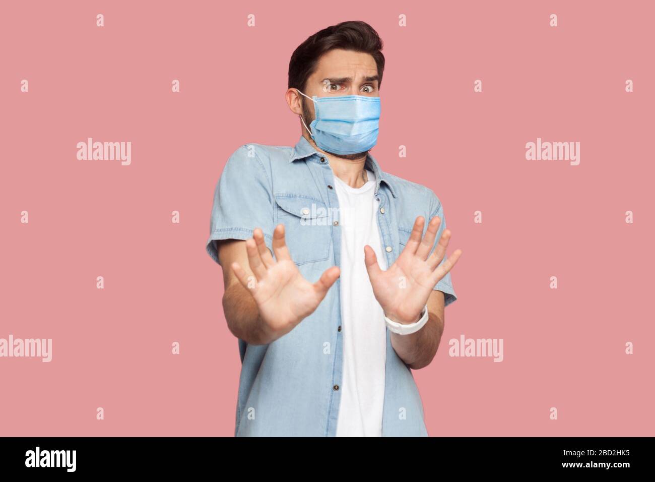 Stop. Portrait of scared man with surgical medical mask in blue shirt ...