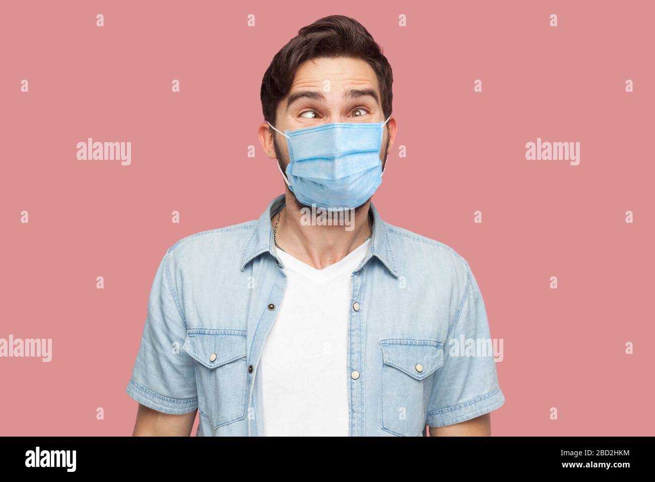 Portrait of crazy young man with surgical medical mask in blue shirt ...