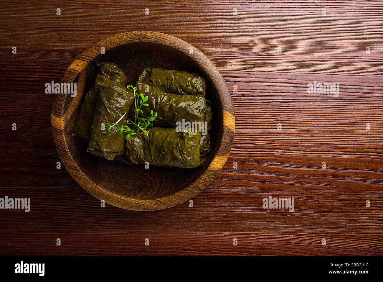 Traditional georgian dolma in grape leaves on wooden background with ...