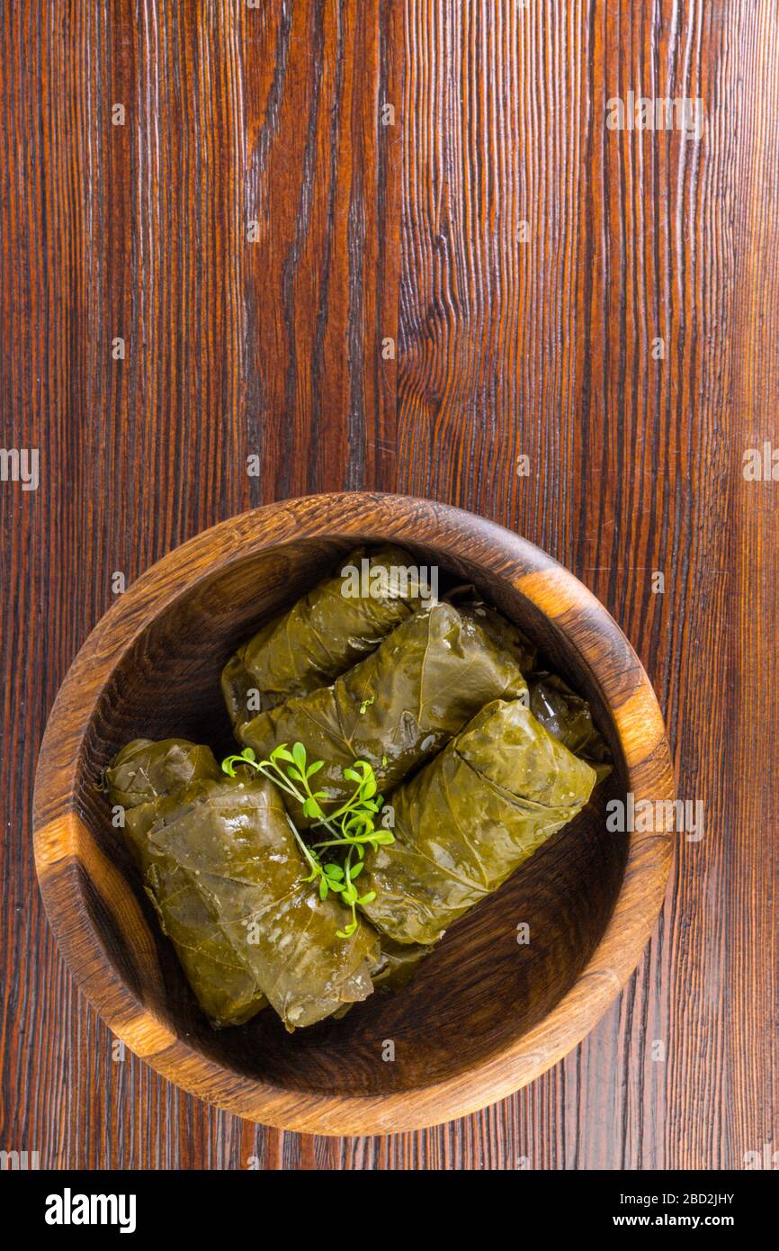 Traditional georgian dolma in grape leaves on wooden background with ...