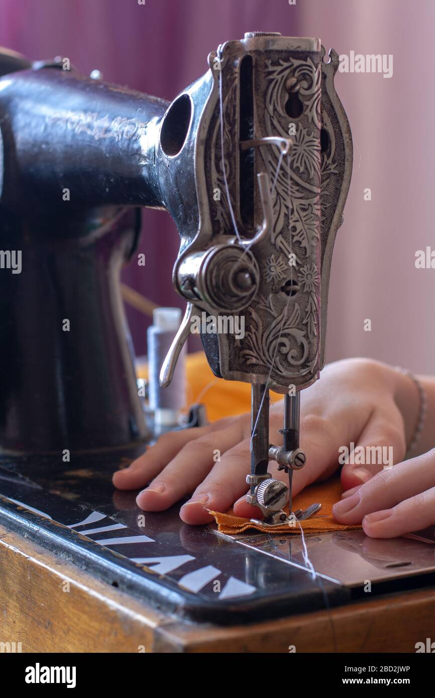Seamstress sews on a retro sewing machine. Shallow depth of field ...