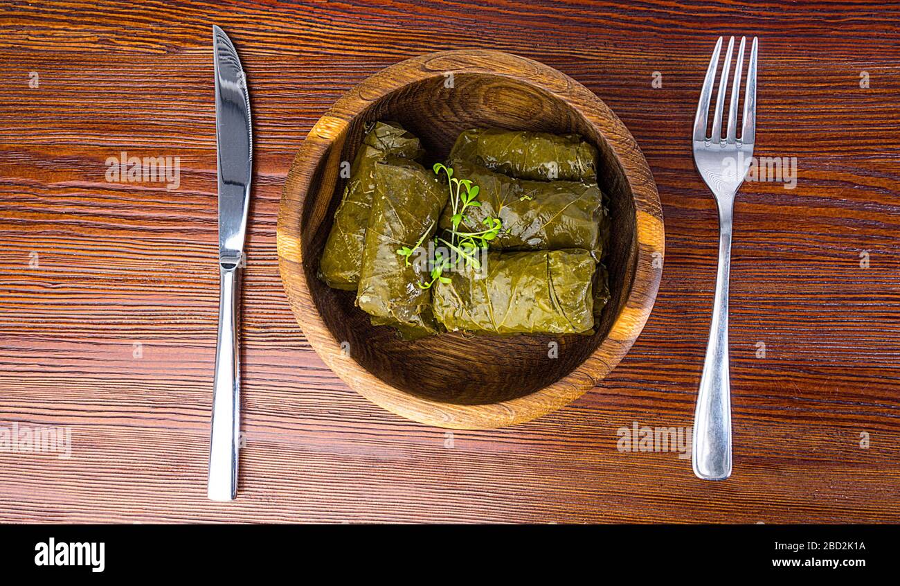 Traditional georgian dolma in grape leaves on wooden background with ...