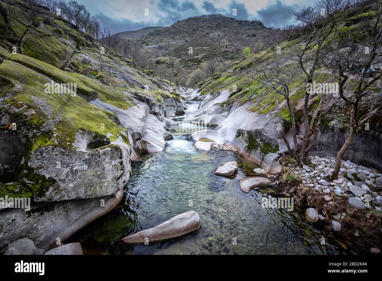 A beautiful valley of two eroded mountains that flows into a river ...