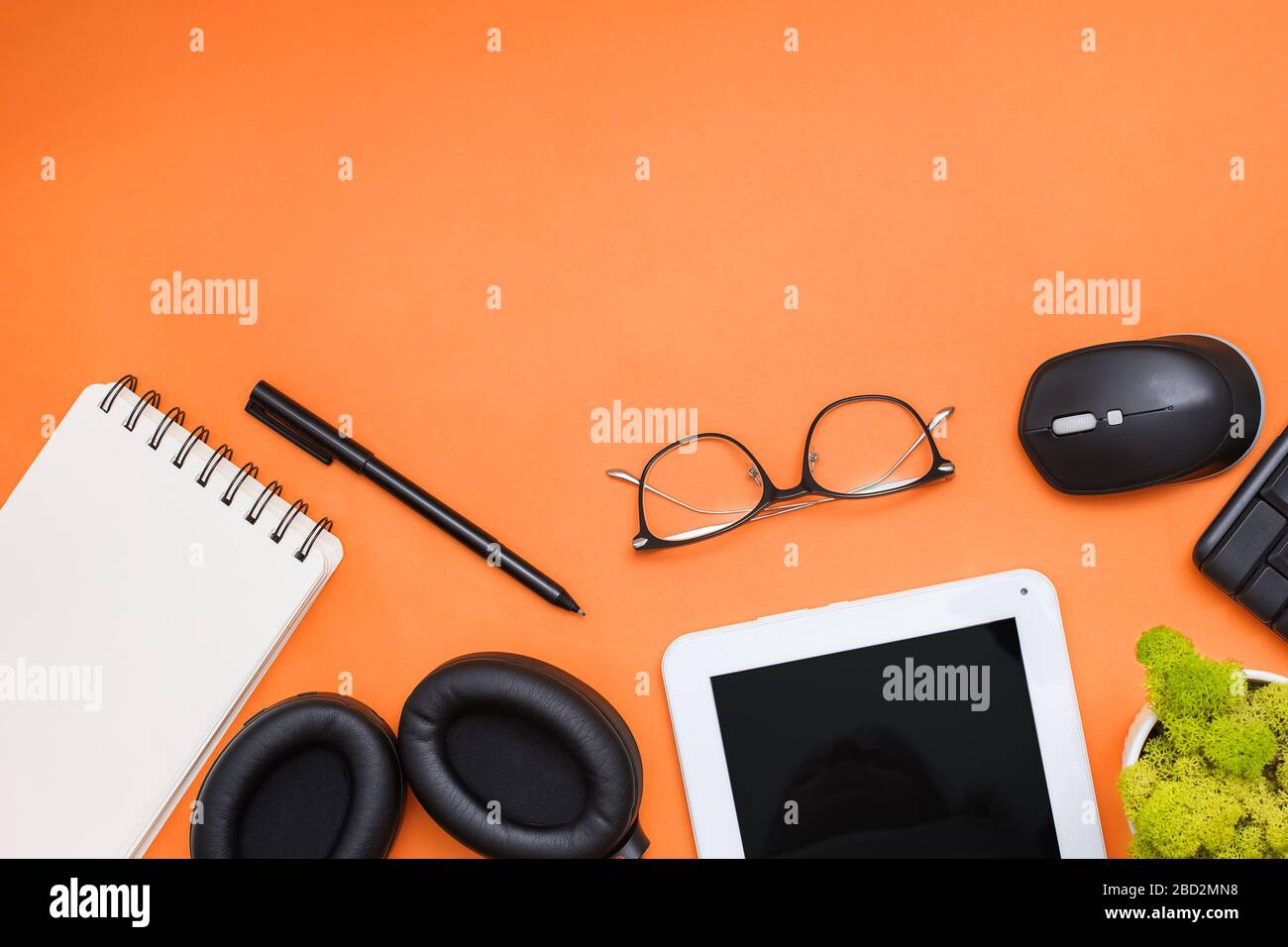 Modern workplace with tablet, earphones and other office related items ...