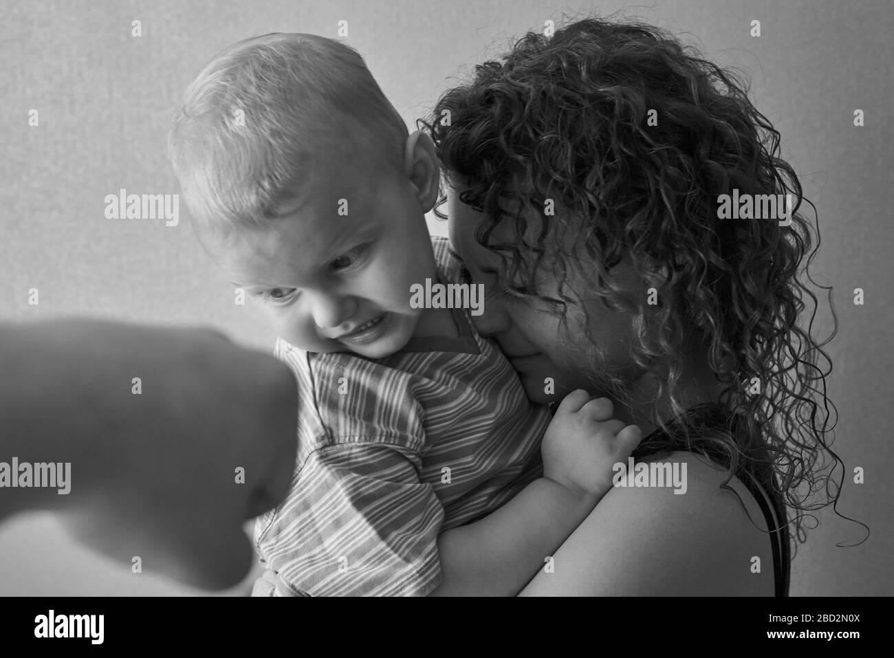 Frightened mother hugs the child in focus, father's fist out of focus ...