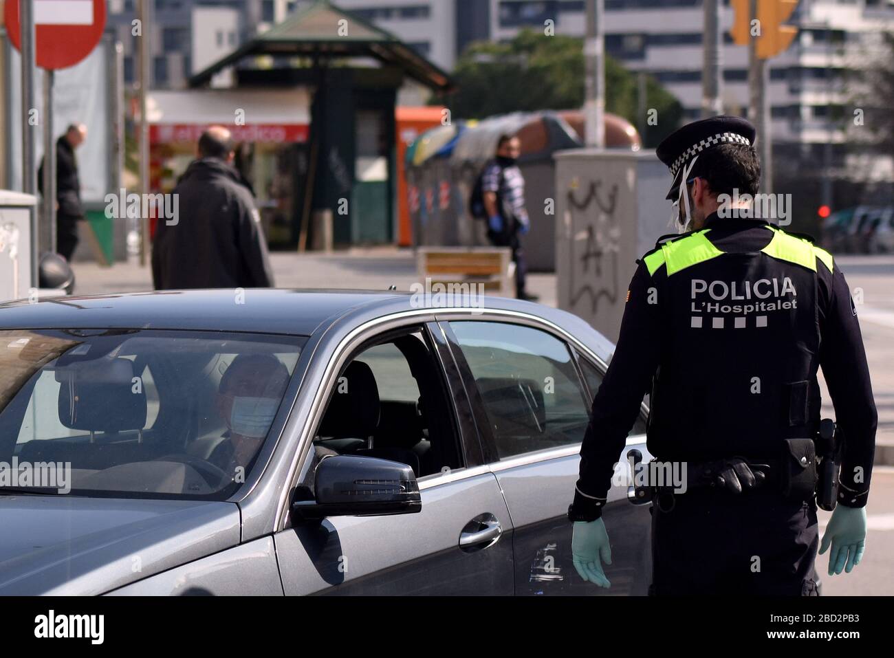 A police officer wearing a face mask and surgical gloves at a ...