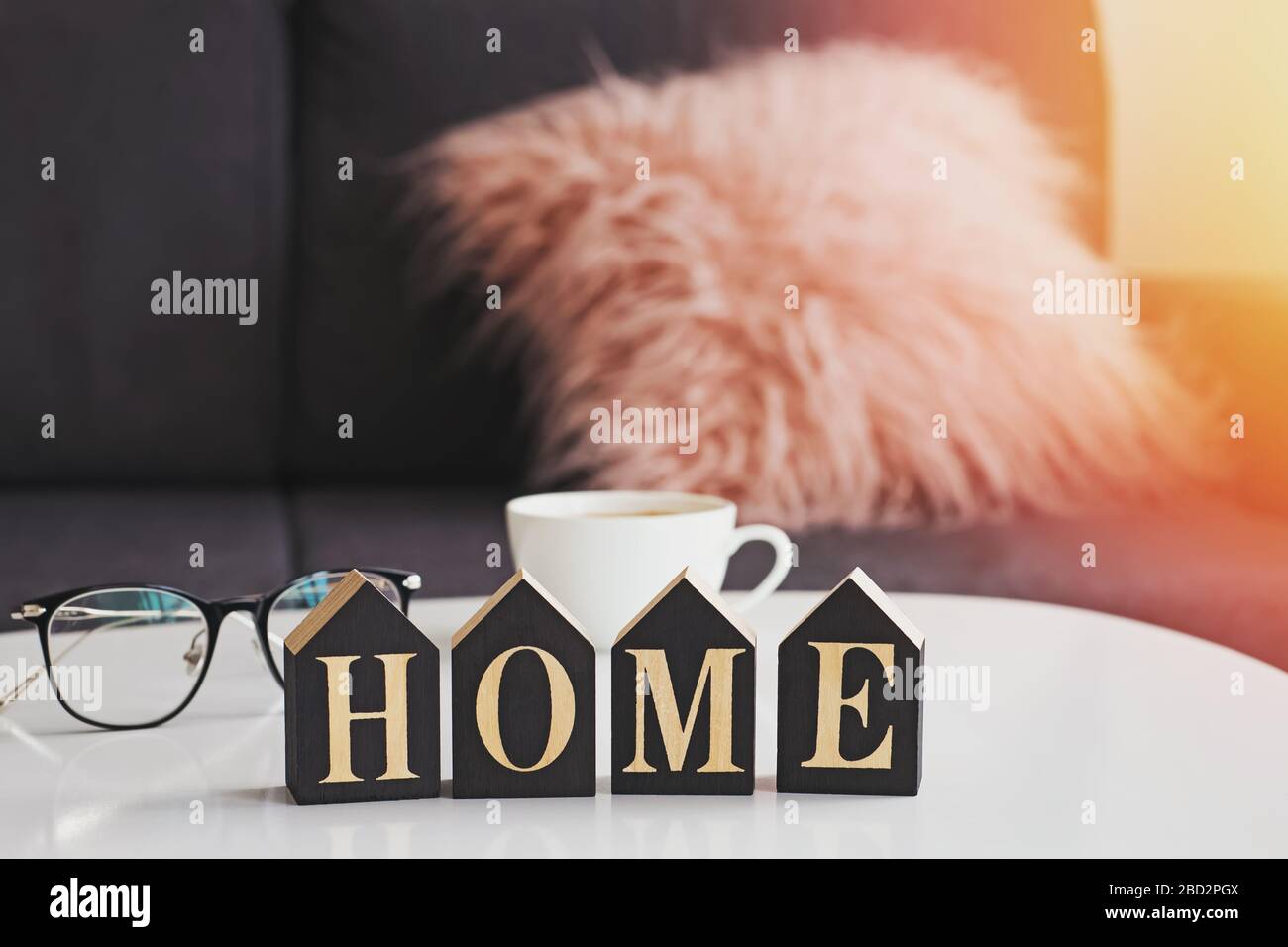 Wooden letters Home on small table with blurred living room on the ...