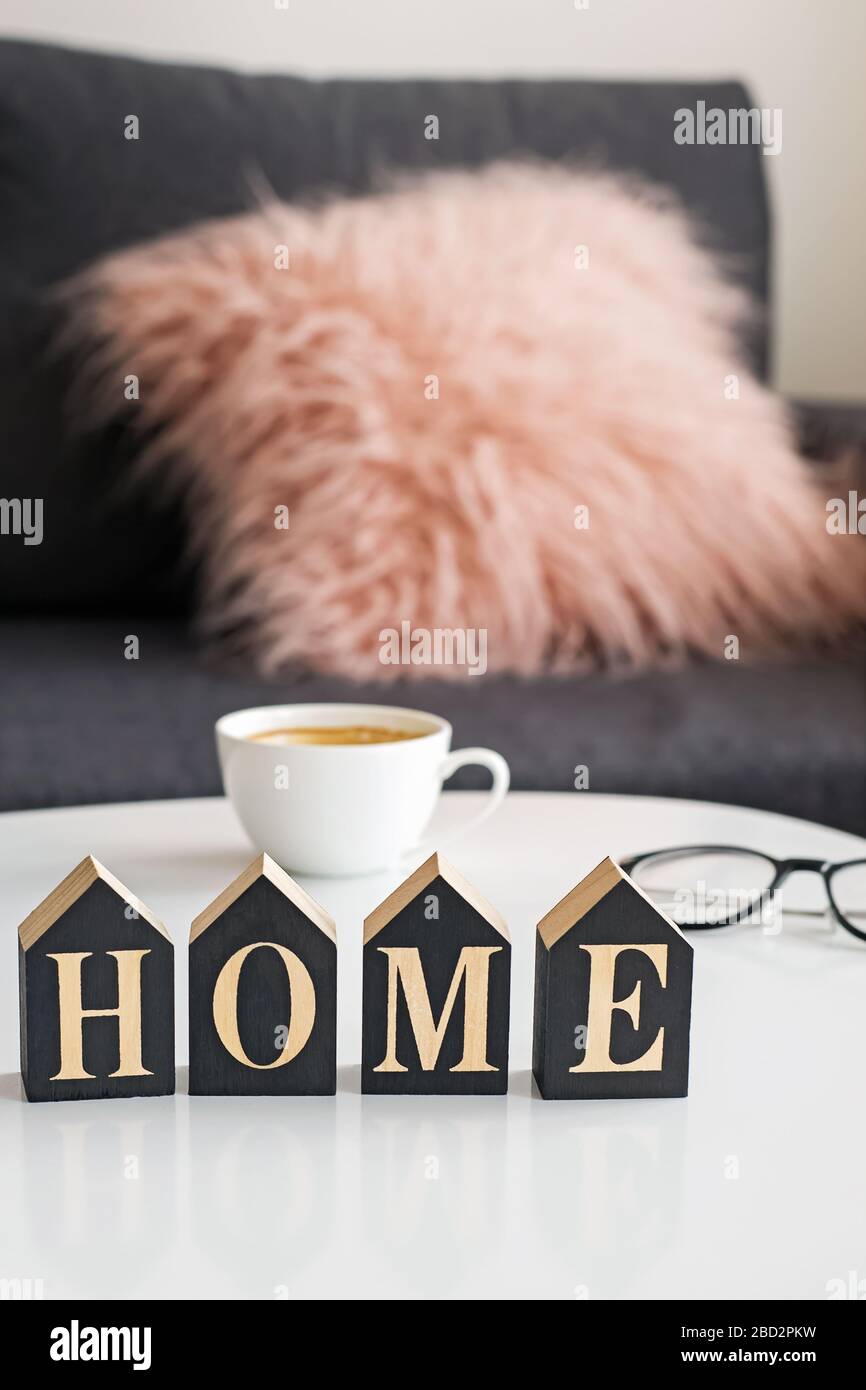 Wooden letters Home on small table with blurred living room on the ...