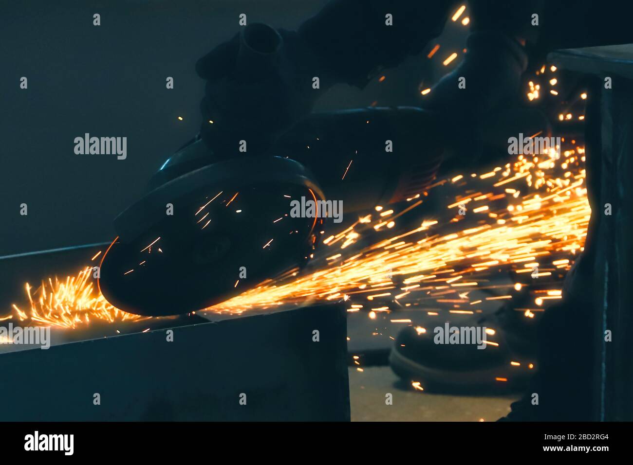 Professional worker cuts metal by angle grinder machine. Fountain of ...