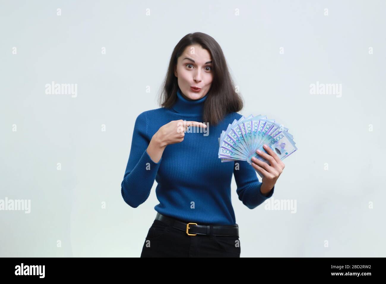 Portrait of the girl, points the finger at the tenge money. White ...