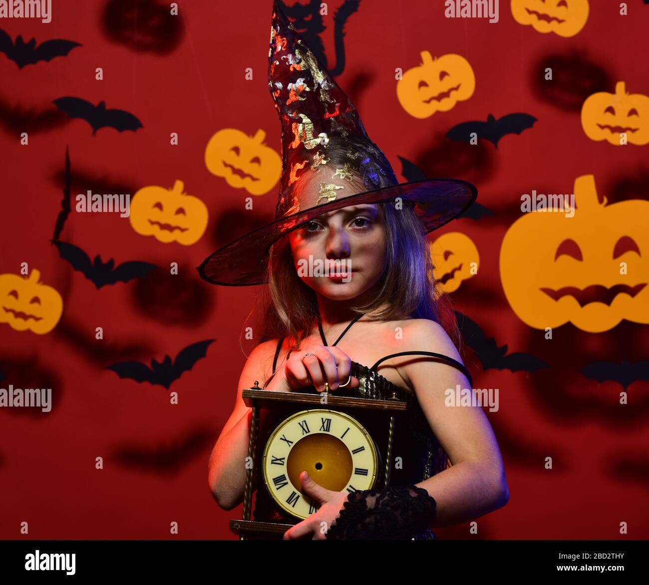 Girl with calm face on bloody red background with bats and pumpkins ...