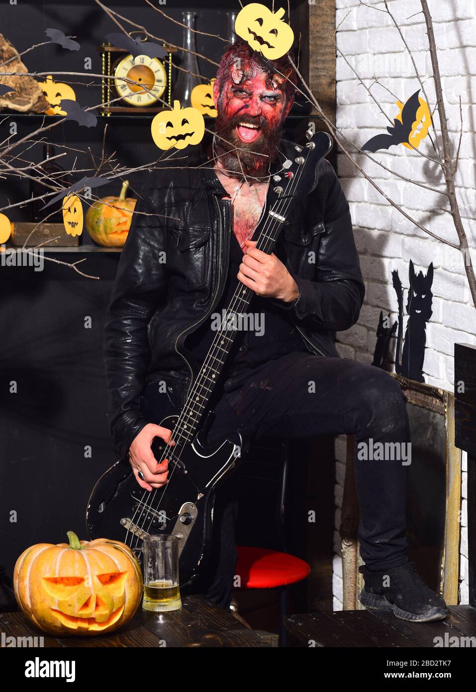 Man wearing scary makeup with Halloween pumpkins and bats decor on ...