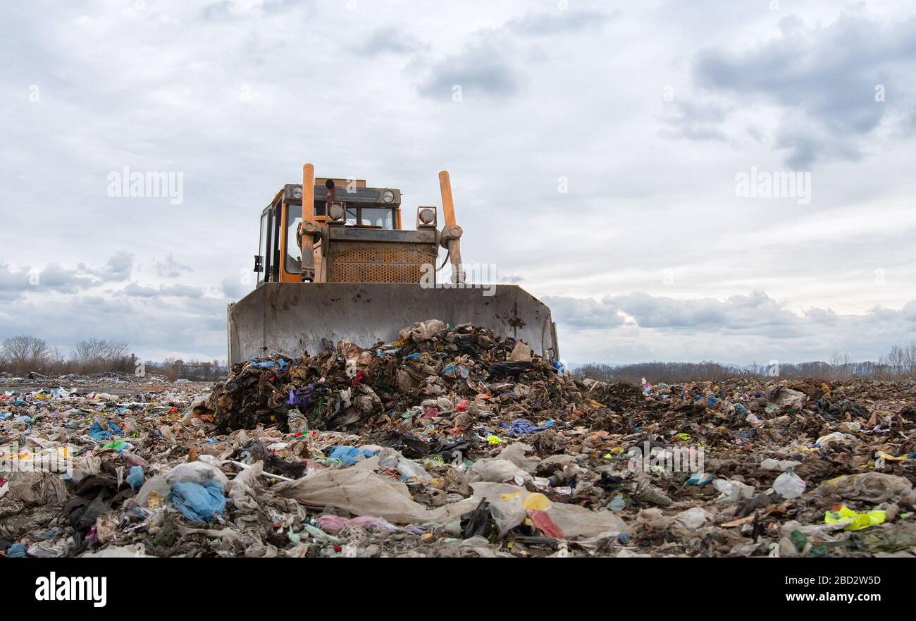 Bulldozer working on mountain of garbage in landfill Stock Photo - Alamy