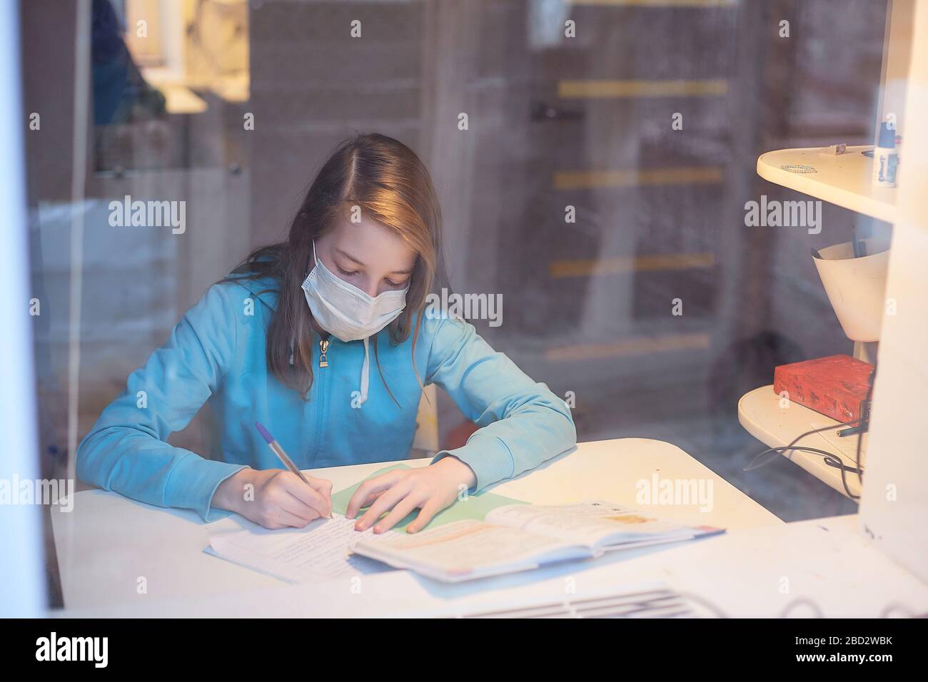 distance learning in quarantine, a teenage girl in a medical mask doing ...