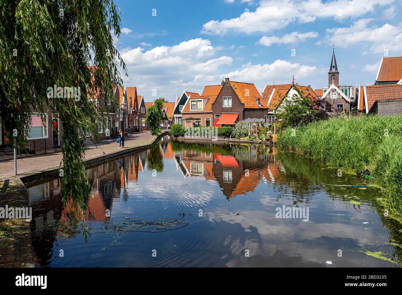 Houses on the canal and church of St. Vincentius, Volendam, North ...