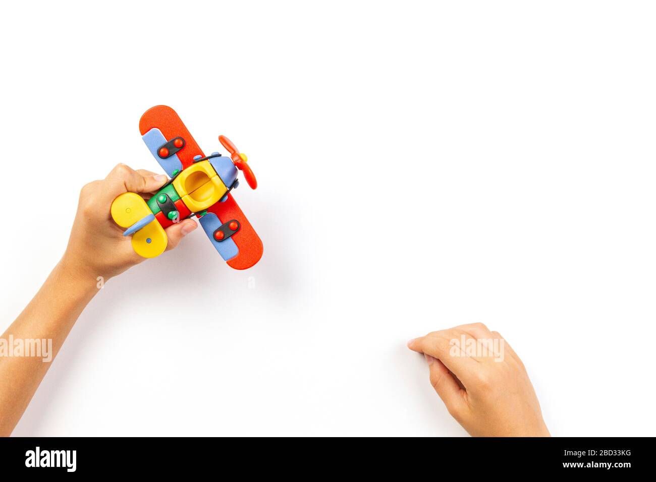 Kid hands play with toy airplane on white background. Top view Stock ...