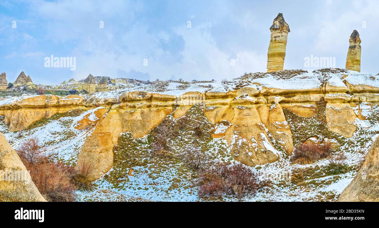 Panorama of bright yellow rocky cliff, shaped by erosion and weathering ...