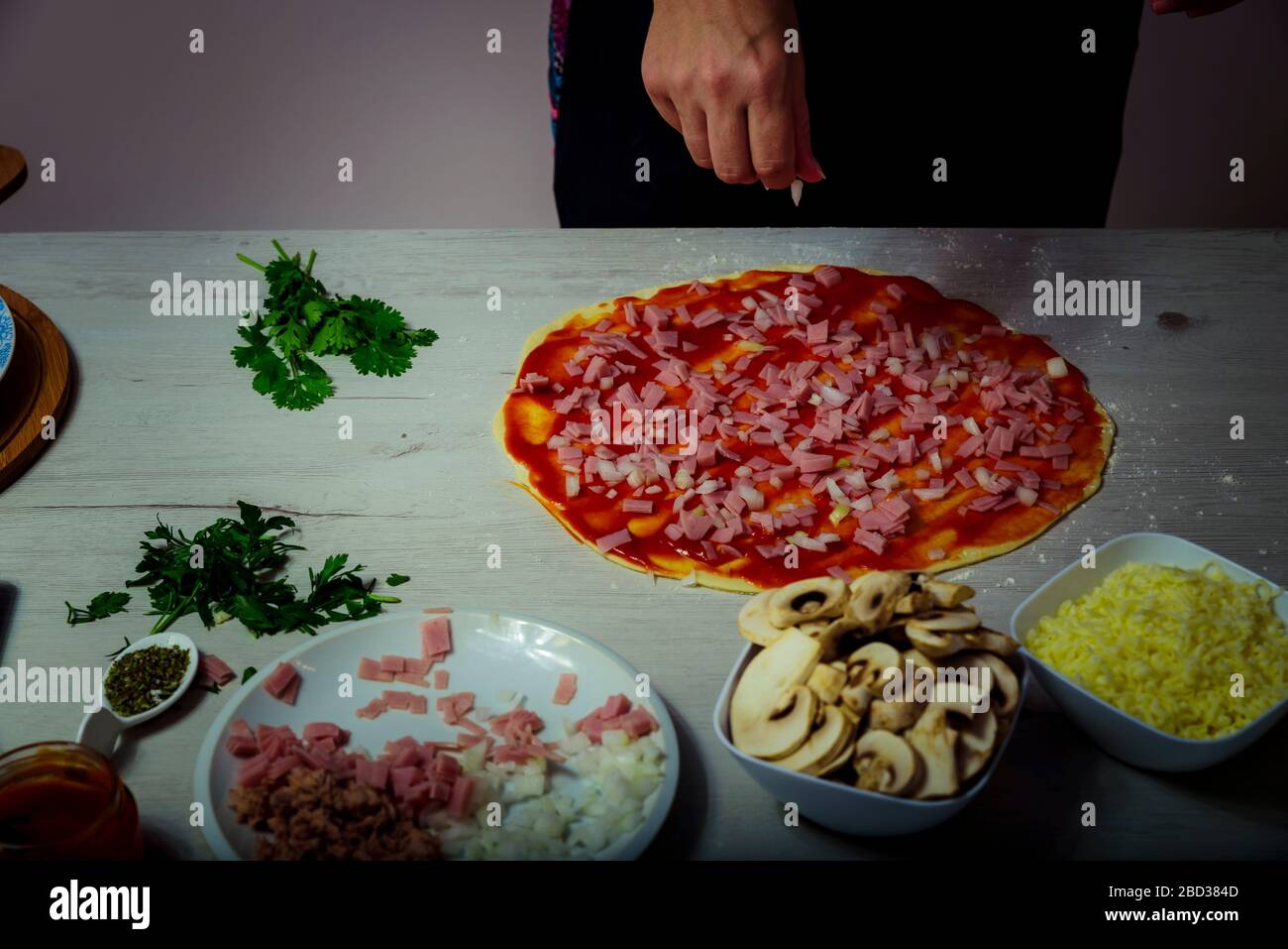 Woman adding ingredients to homemade pizza dough. cooking concept Stock ...