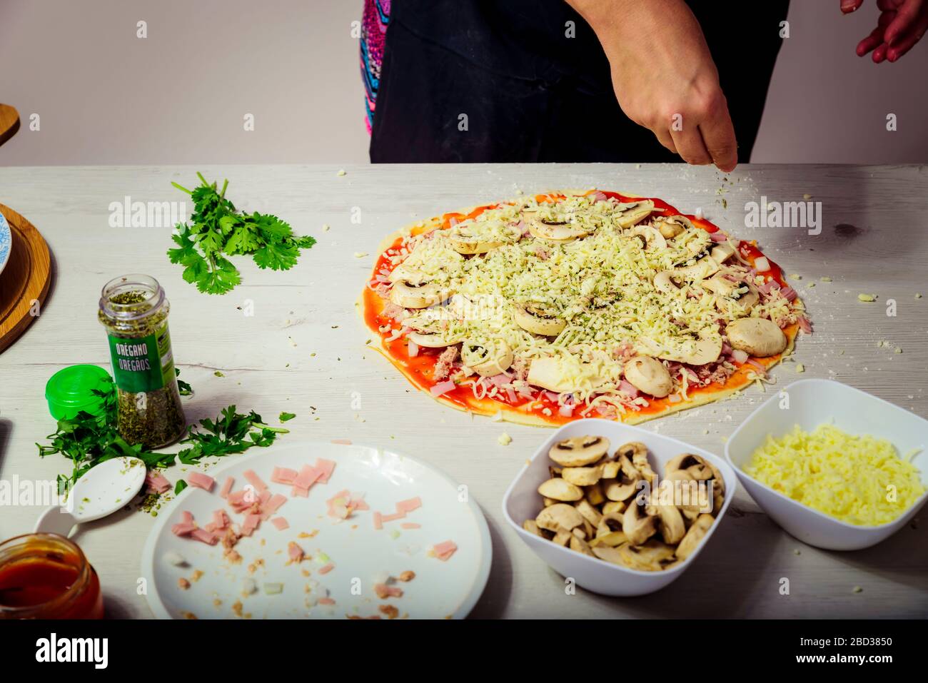 Woman adding ingredients to homemade pizza dough. cooking concept Stock ...
