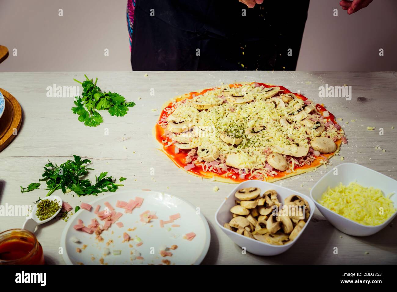 Woman adding ingredients to homemade pizza dough. cooking concept Stock ...