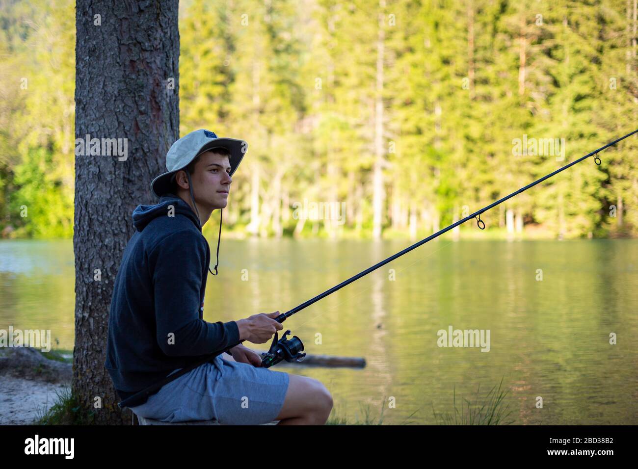 Man fishing at lake in a beautiful green nature Stock Photo - Alamy