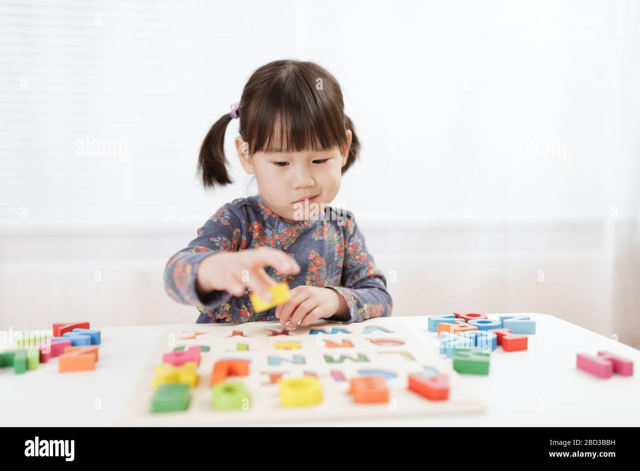 toddler girl learning letter blocks for homeschooling Stock Photo - Alamy