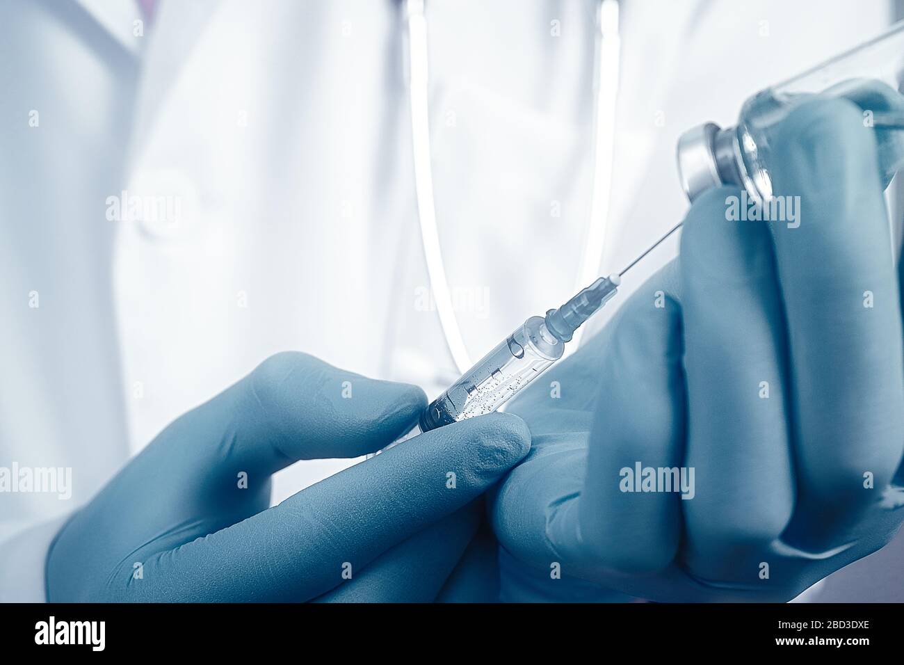 Close up doctor arm using syringe and ampoule, white robe dressed ...