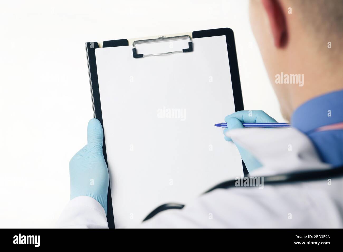 Doctor holding medical clipboard with empty blank sheet of paper and ...