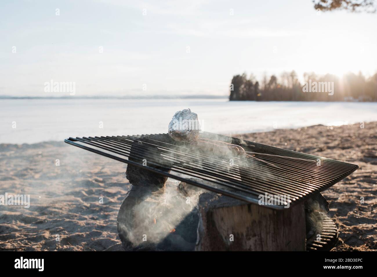 food cooking on an outdoor fire at the beach at sunset in Sweden Stock ...
