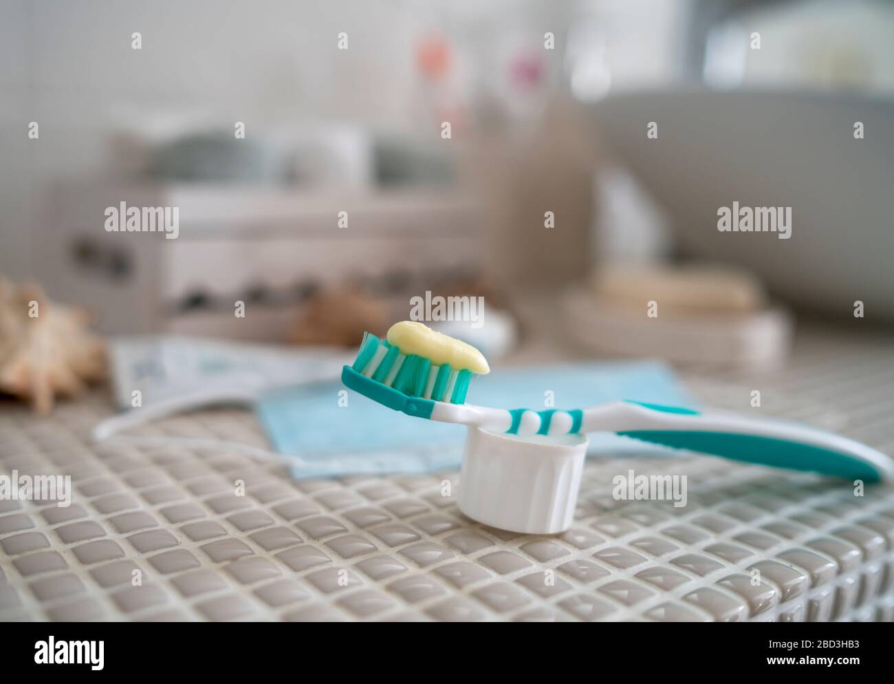 Open toothpaste, a toothbrush, and a medical mask that has been removed ...