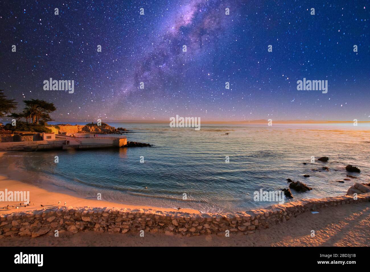 Pacific Grove beach and pier late at night with sky ablaze with stars ...